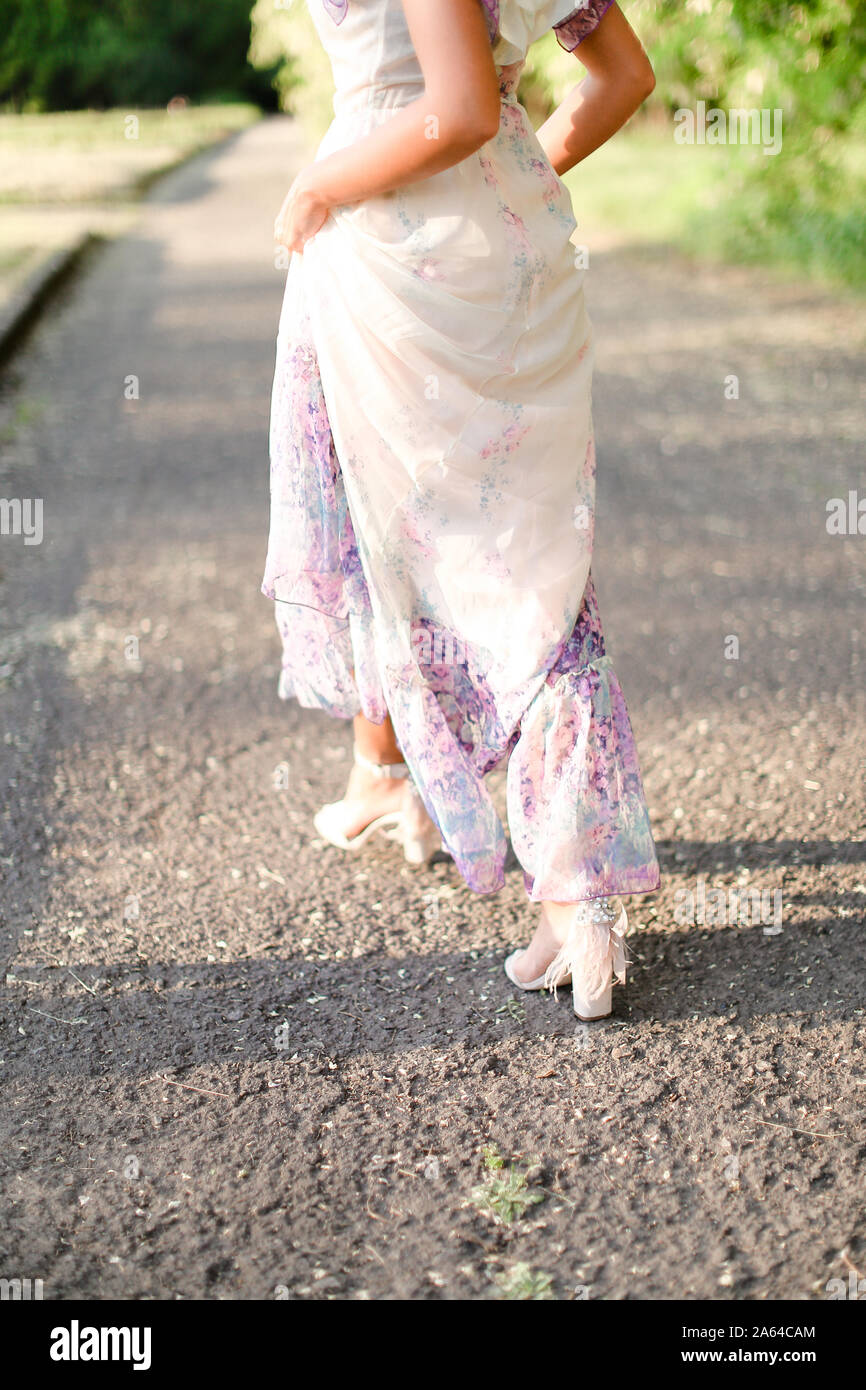 Back view of woman wearing white dress walking outside Stock Photo - Alamy