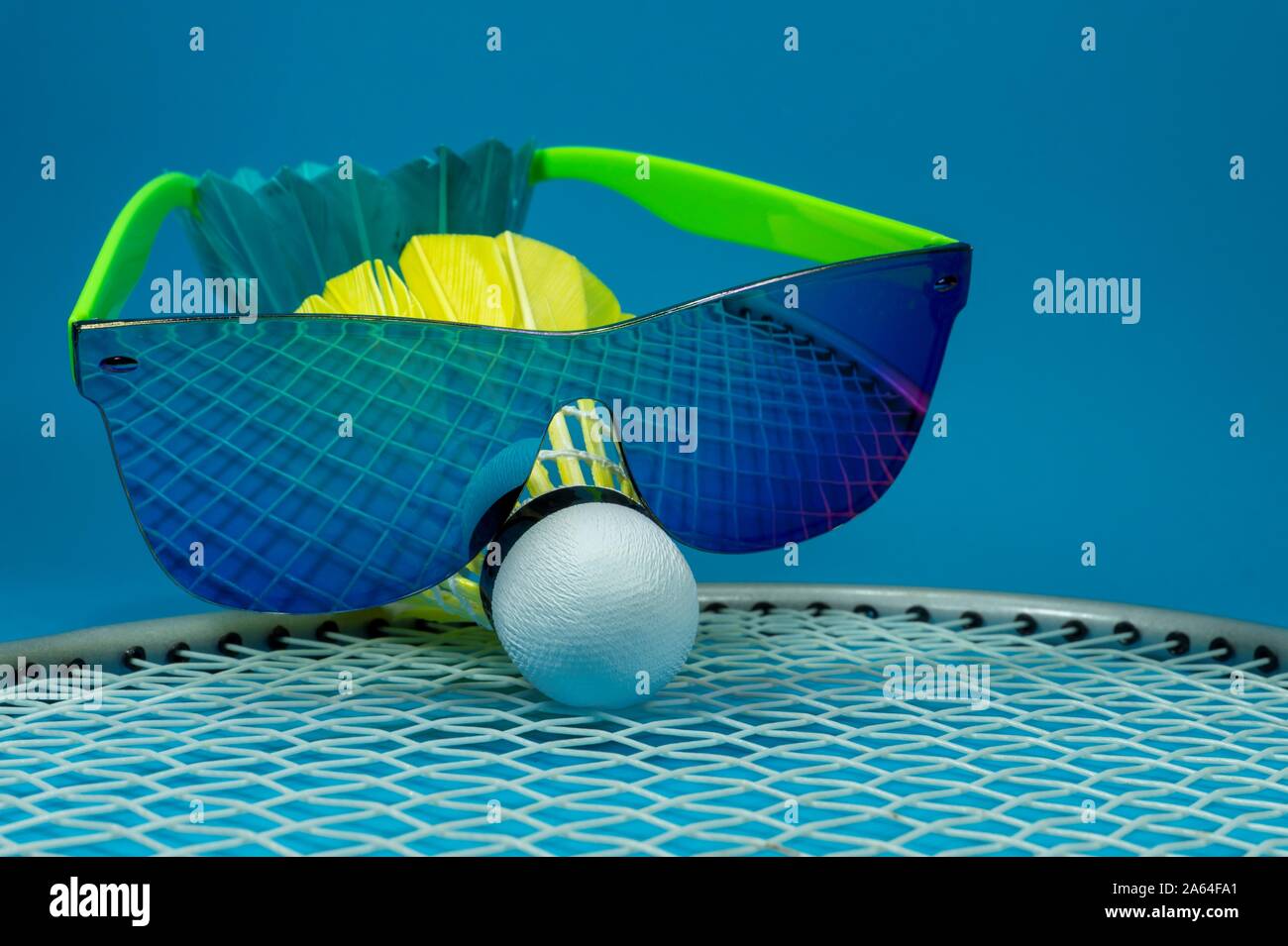 Colorful feathered badminton shuttlecock with sunglasses resting on a ...