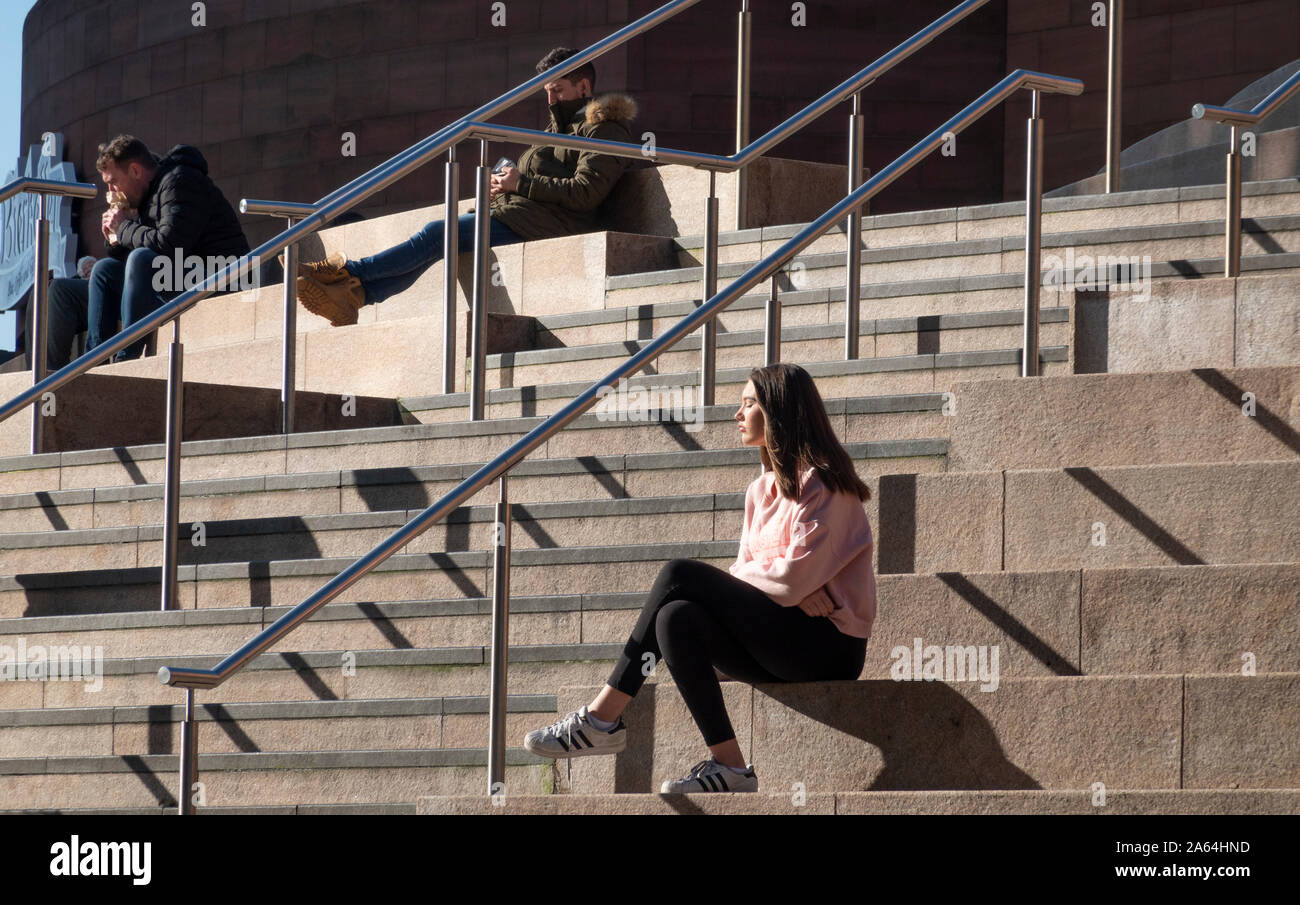 Beautiful young woman taking the sun on the steps of Liverpool One ...