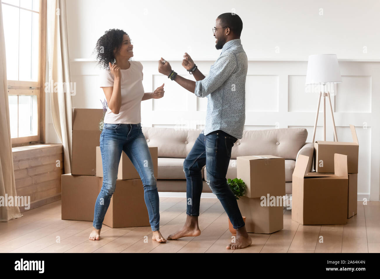 Happy black couple dancing in living room on moving day Stock Photo - Alamy