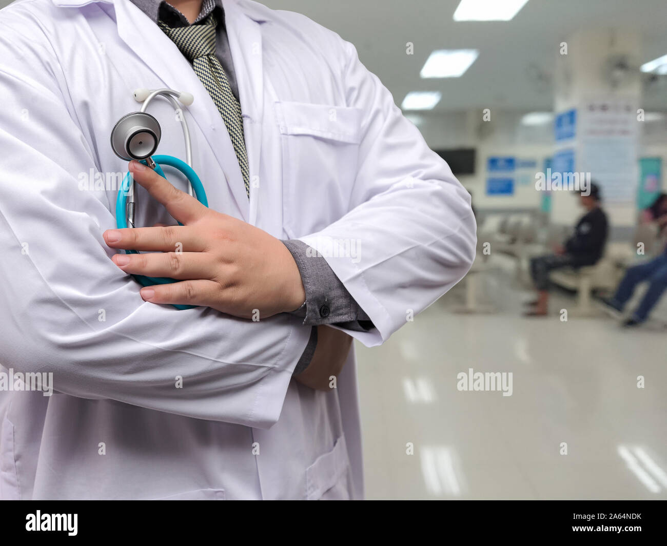 Doctor in gown uniform with stethoscope standing and fold his arms over ...