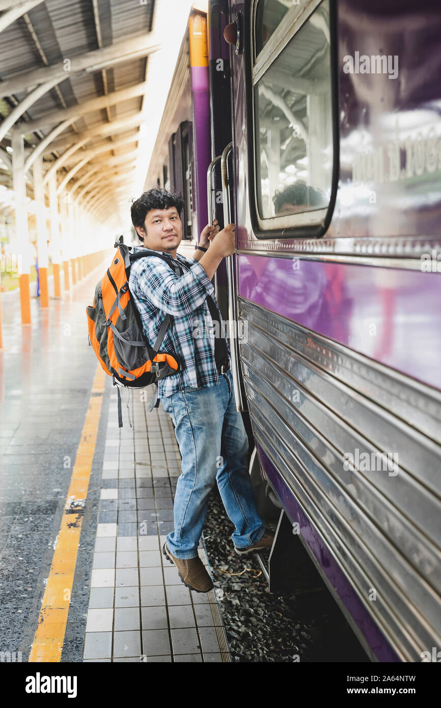 Asian man traveler with backpack is stepping up the train in train ...