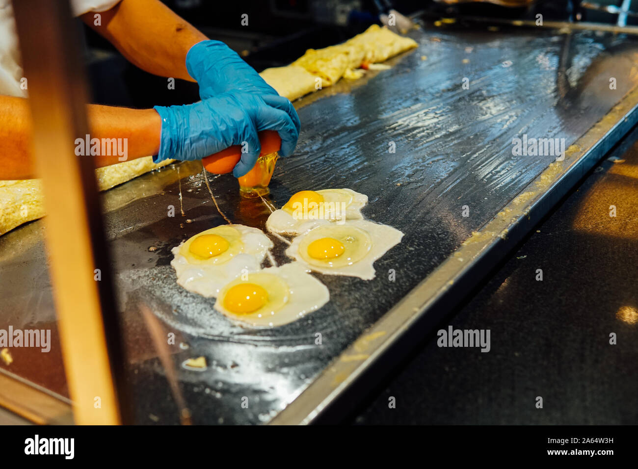 the Cook prepares the eggs in the kitchen of the restaurant Stock Photo ...