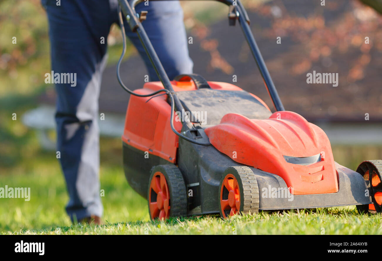 man mows the lawn grass with a lawn mower Stock Photo - Alamy
