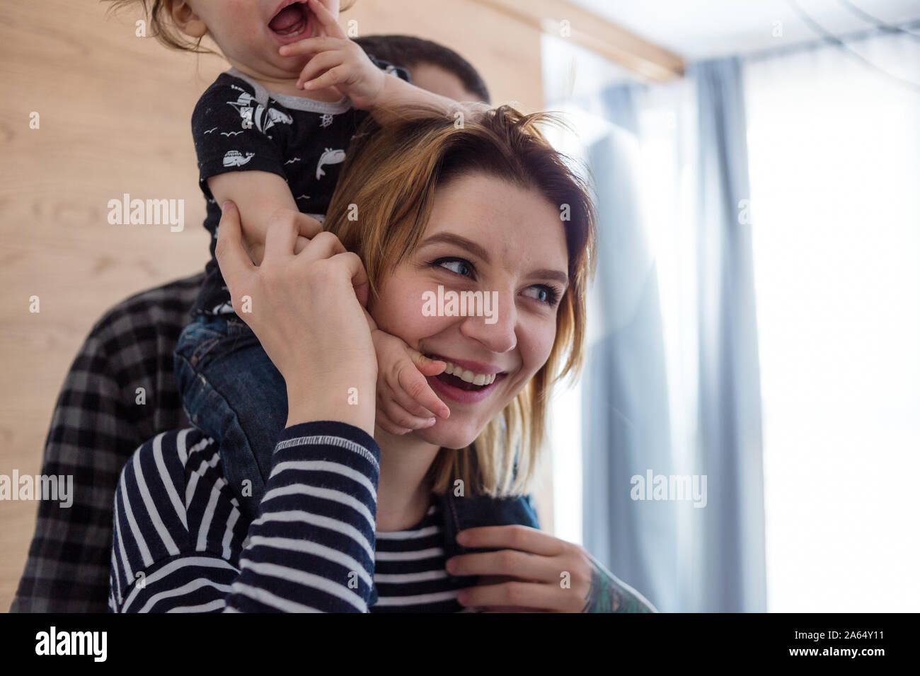 Mother giving her baby a piggyback ride around the house Stock Photo ...