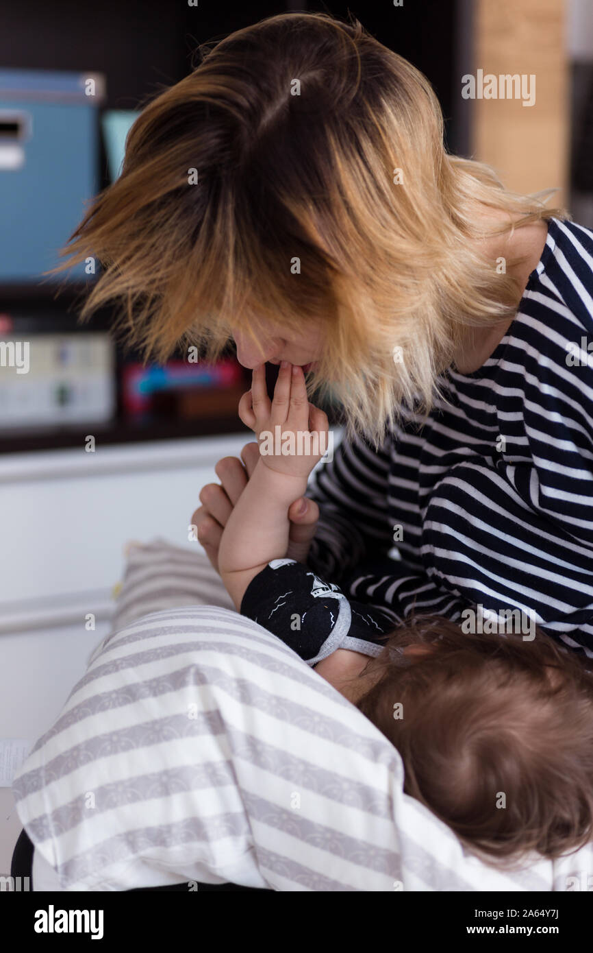 Modest anonymous mother breastfeeding one year old at home Stock Photo ...