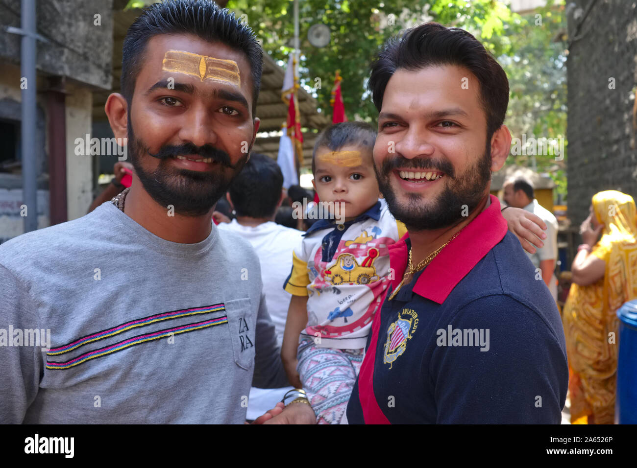 Male relatives with a toddler at a neighborhood celebration in Mumbai ...