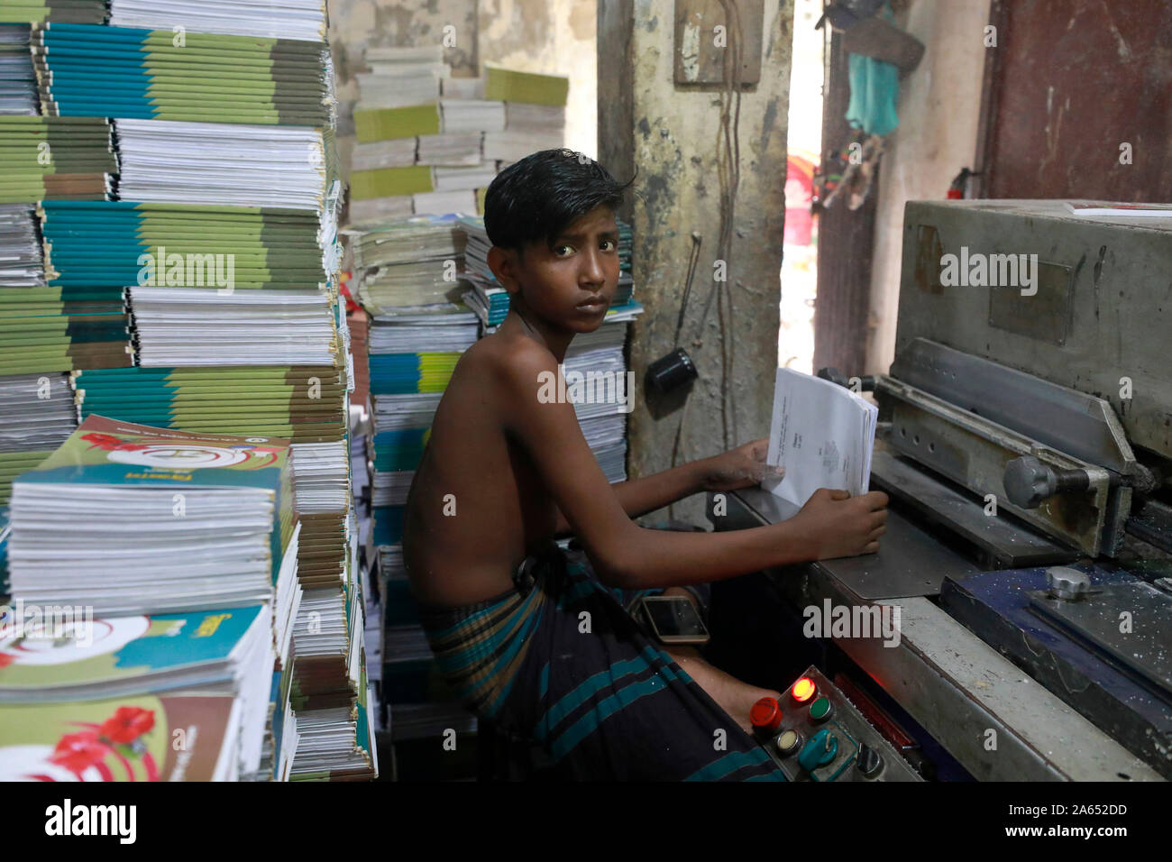 Dhaka, Bangladesh - October 22, 2019. Bangladeshi book binding worker ...
