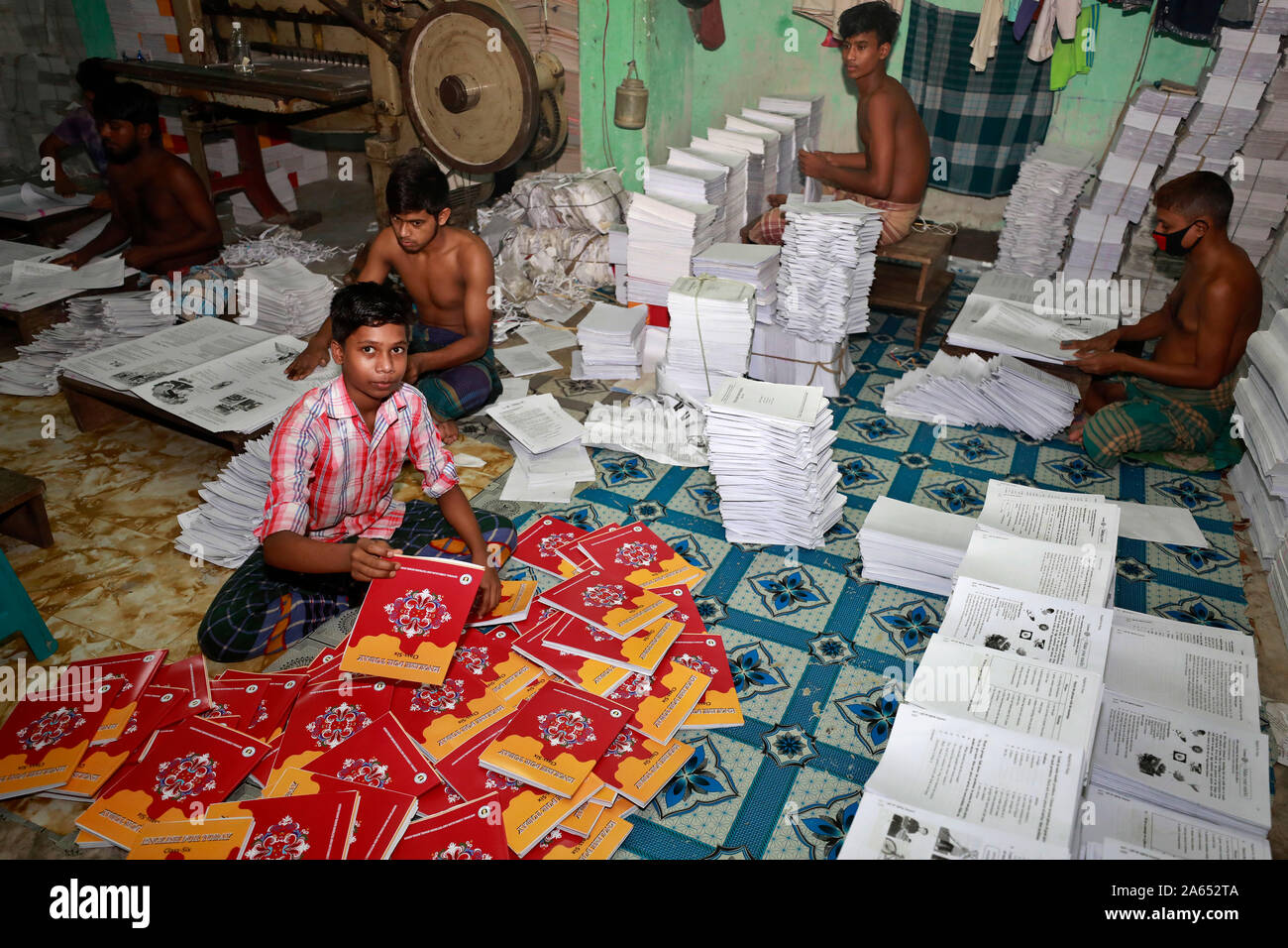 Dhaka, Bangladesh - October 22, 2019. Bangladeshi book binding worker working in a printing ...