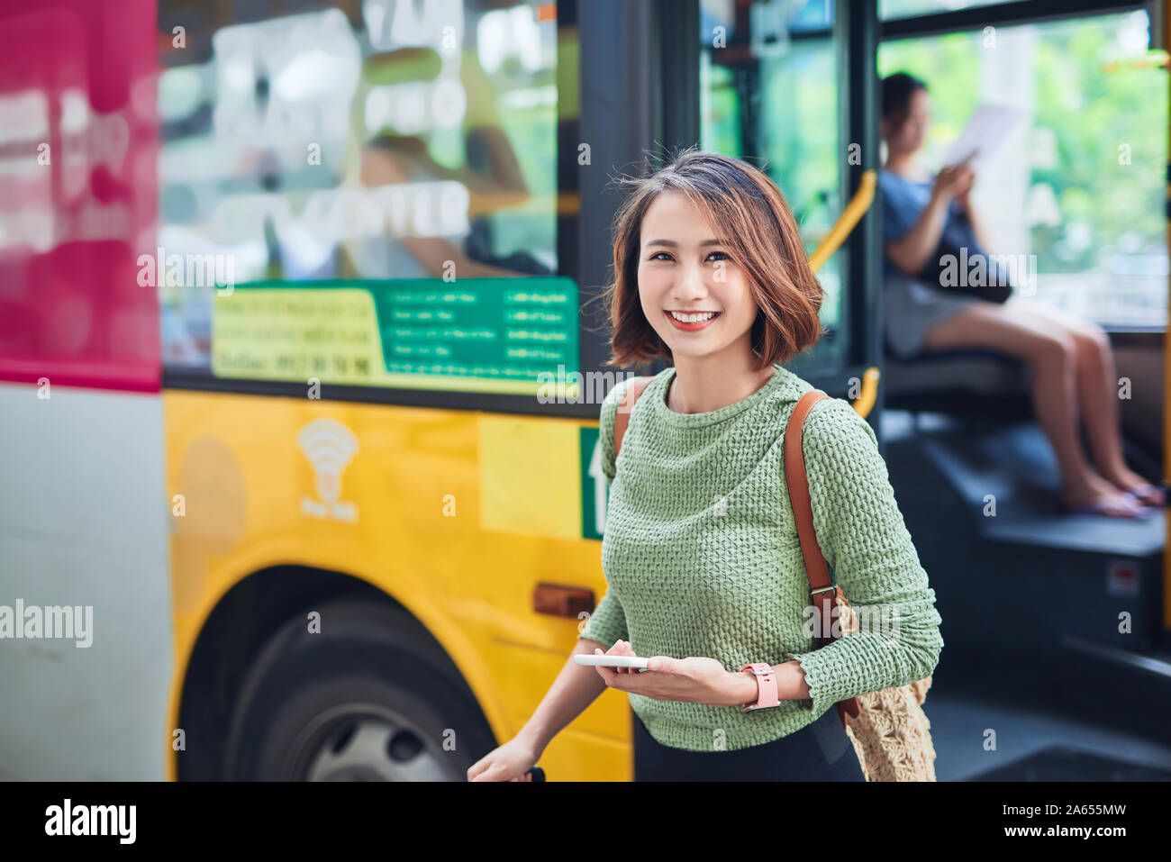 Female traveler going off the bus at terminal Stock Photo - Alamy