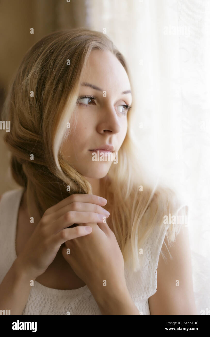 Sad woman looking through the glass window Stock Photo - Alamy