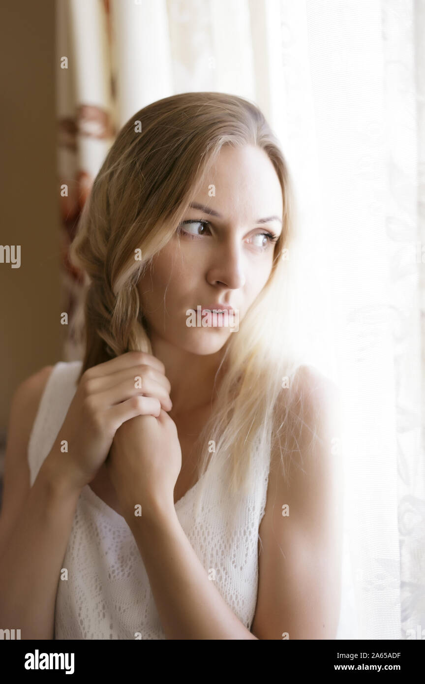 Sad woman looking through the glass window Stock Photo - Alamy