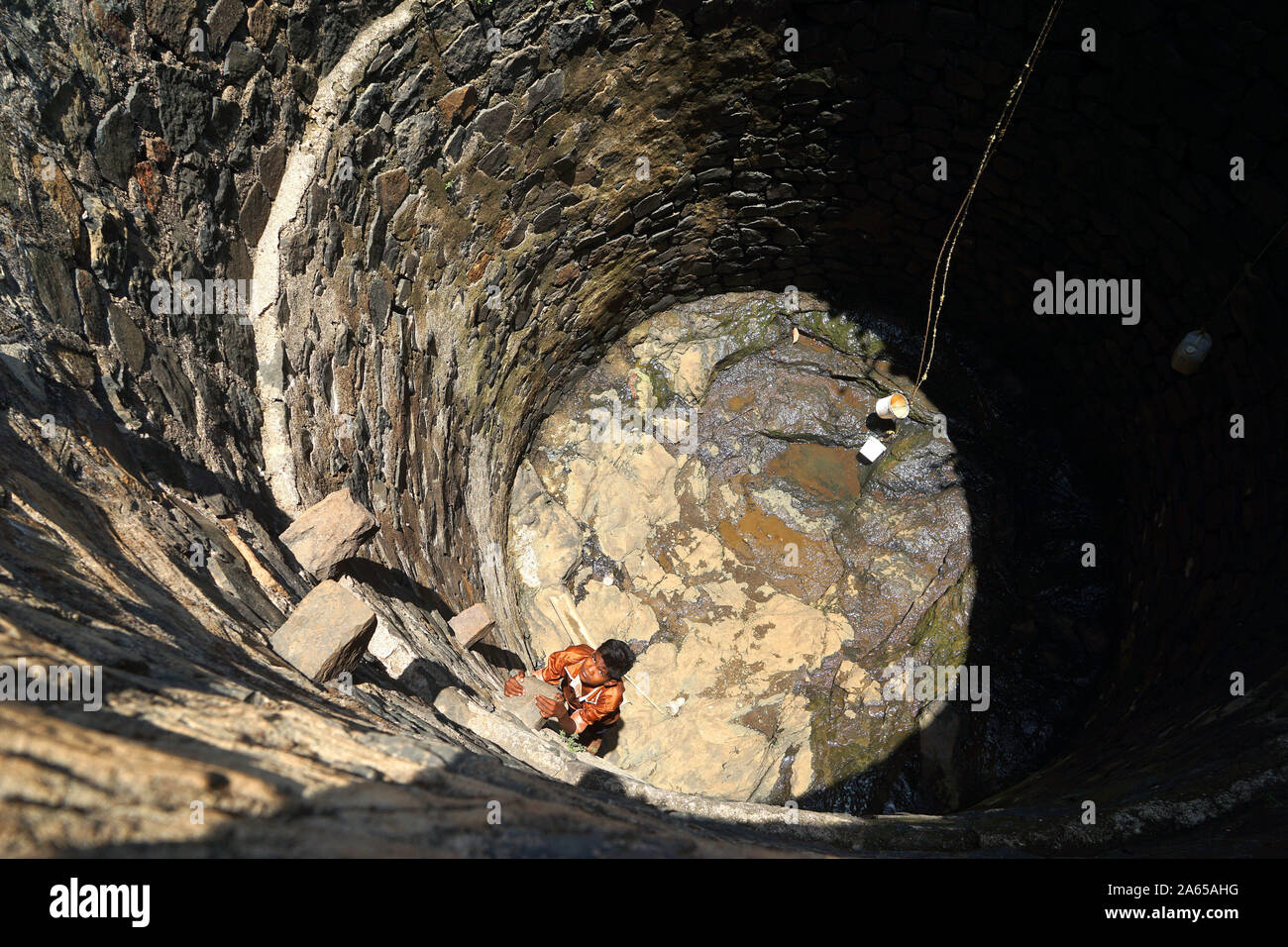 Boy going down in well to collect water, Dhakne village, Shahapur Thane ...