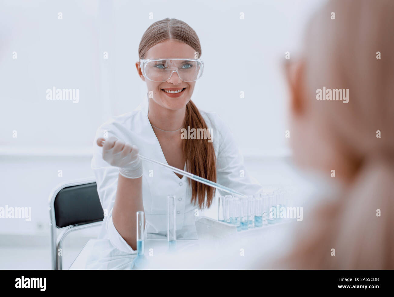 female lab technician testing liquid in vials Stock Photo - Alamy