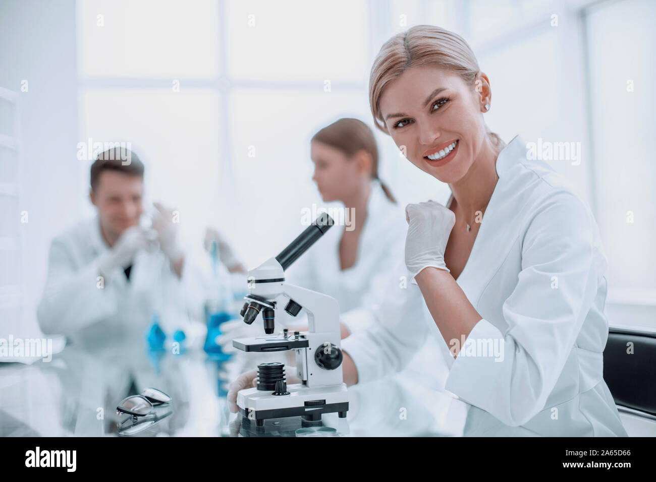 successful female scientist sitting in front of a microscope Stock ...