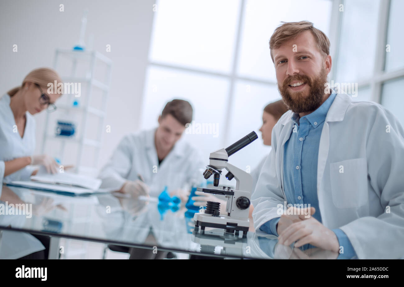successful young scientist sitting at his Desk in the laboratory Stock ...