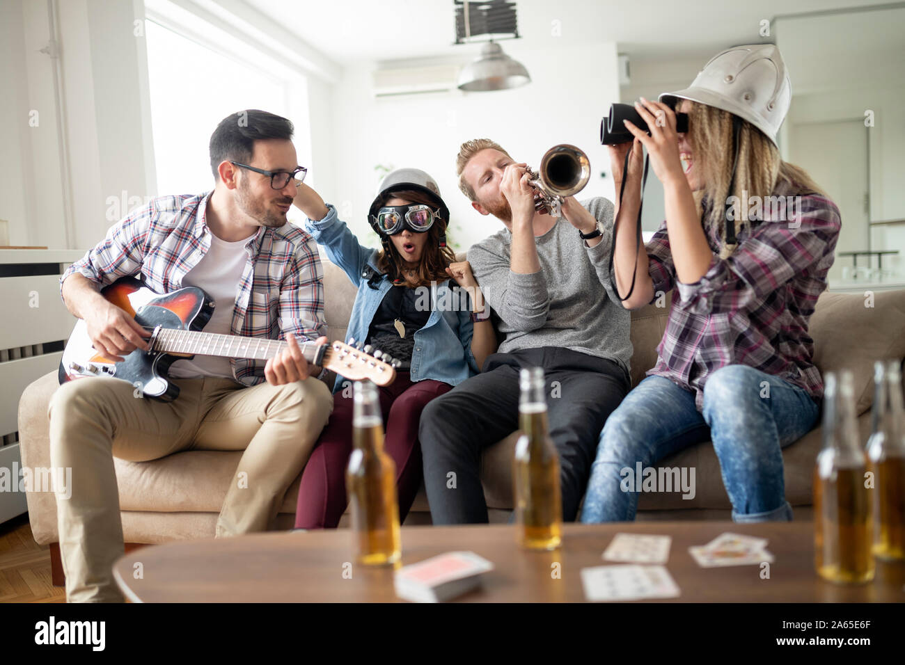 Group of young friends having fun together and playing in music band ...