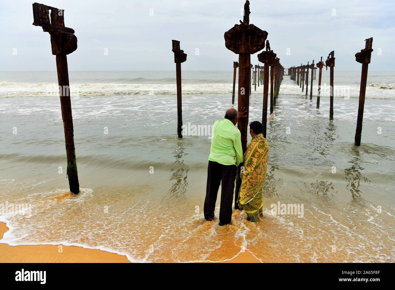 Couple seeing old rusted damaged pier, Alappuzha Beach, Alleppey ...