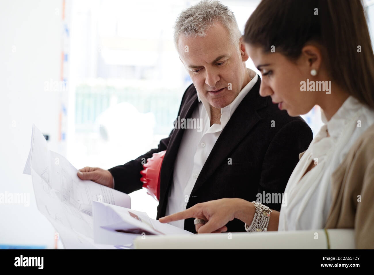Teamwork With Boss And Assistant Looking At Plans In Building Stock ...