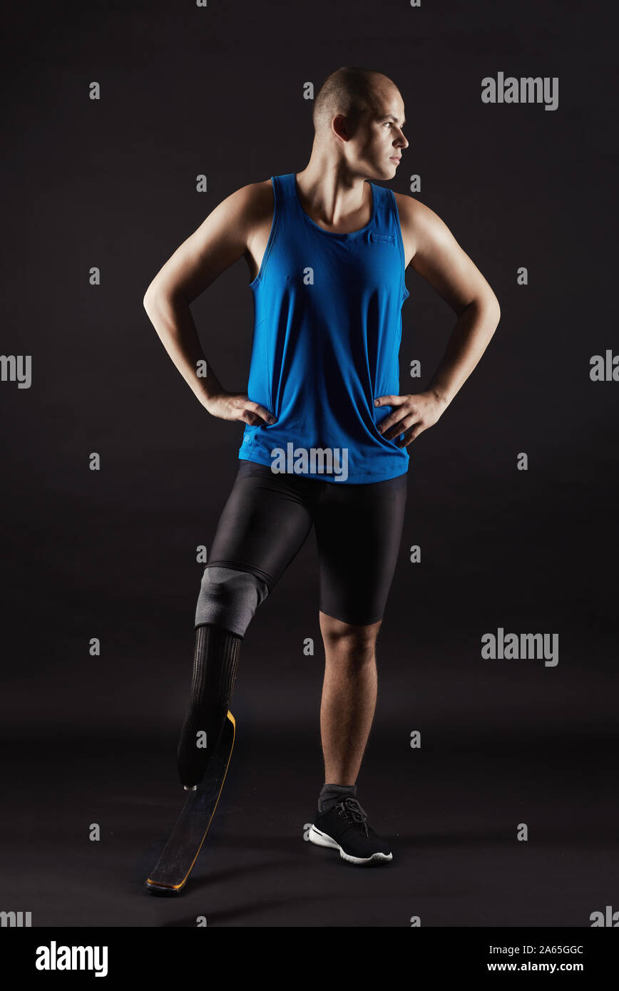 Portrait of young paralympic runner in sports clothing posing at camera ...