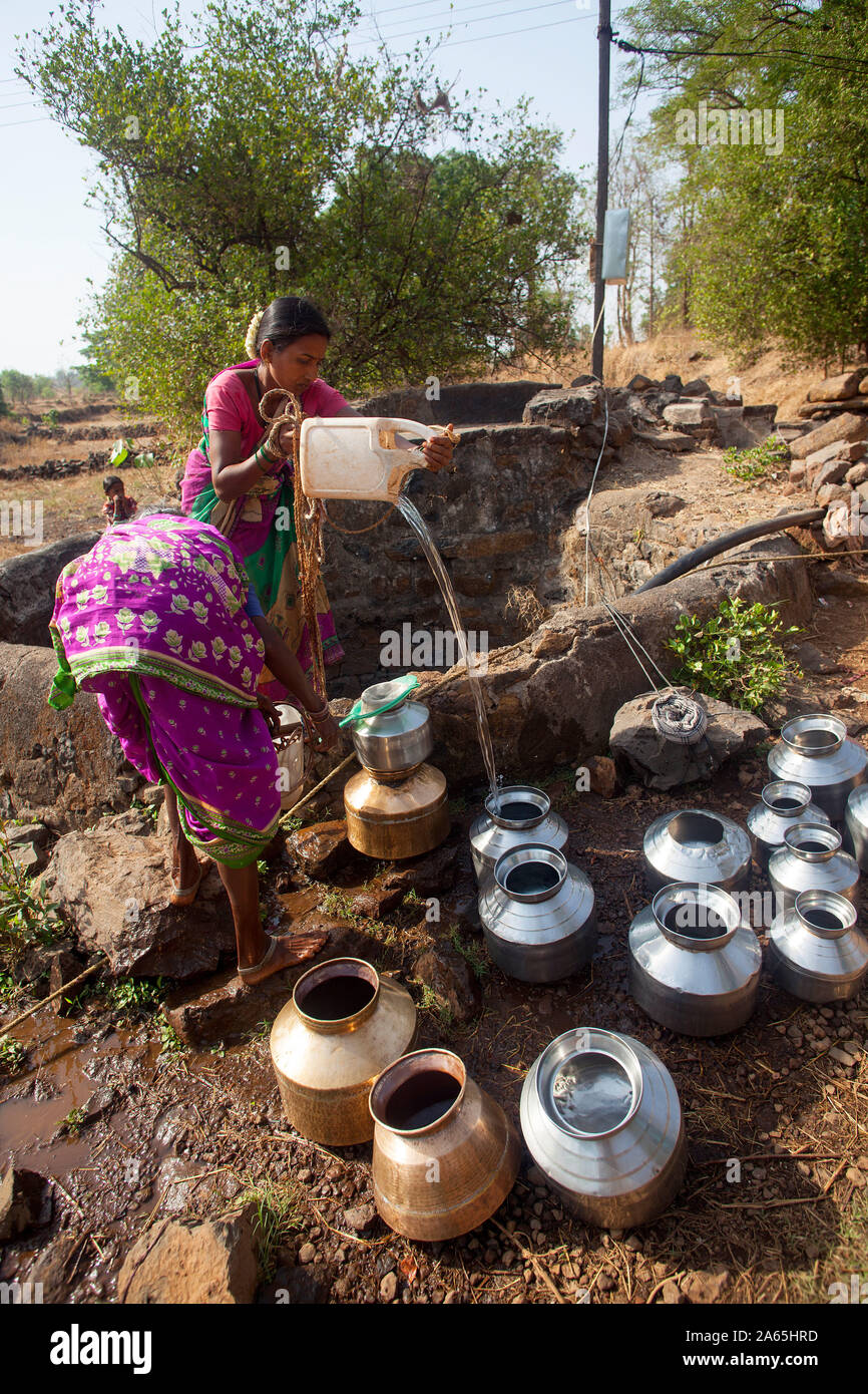 Women collecting water from well at village near Shahapur, Mumbai ...