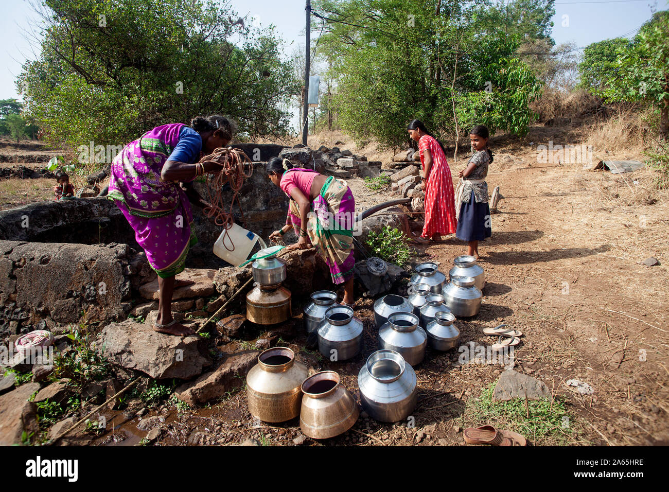 Women collecting water from well at village near Shahapur, Mumbai ...