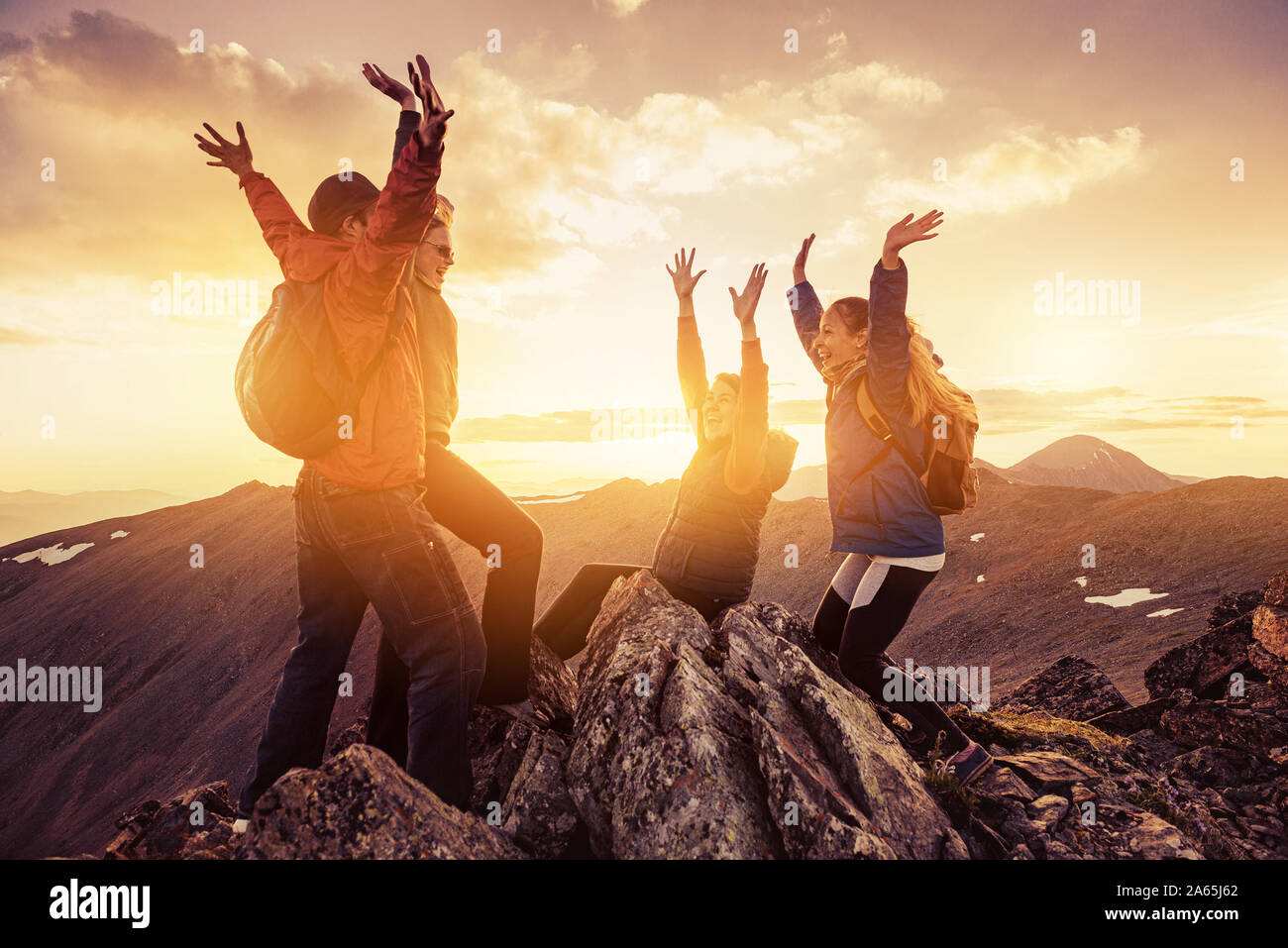 Four happy hikers celebrating climbing on mountain top at sunset Stock ...