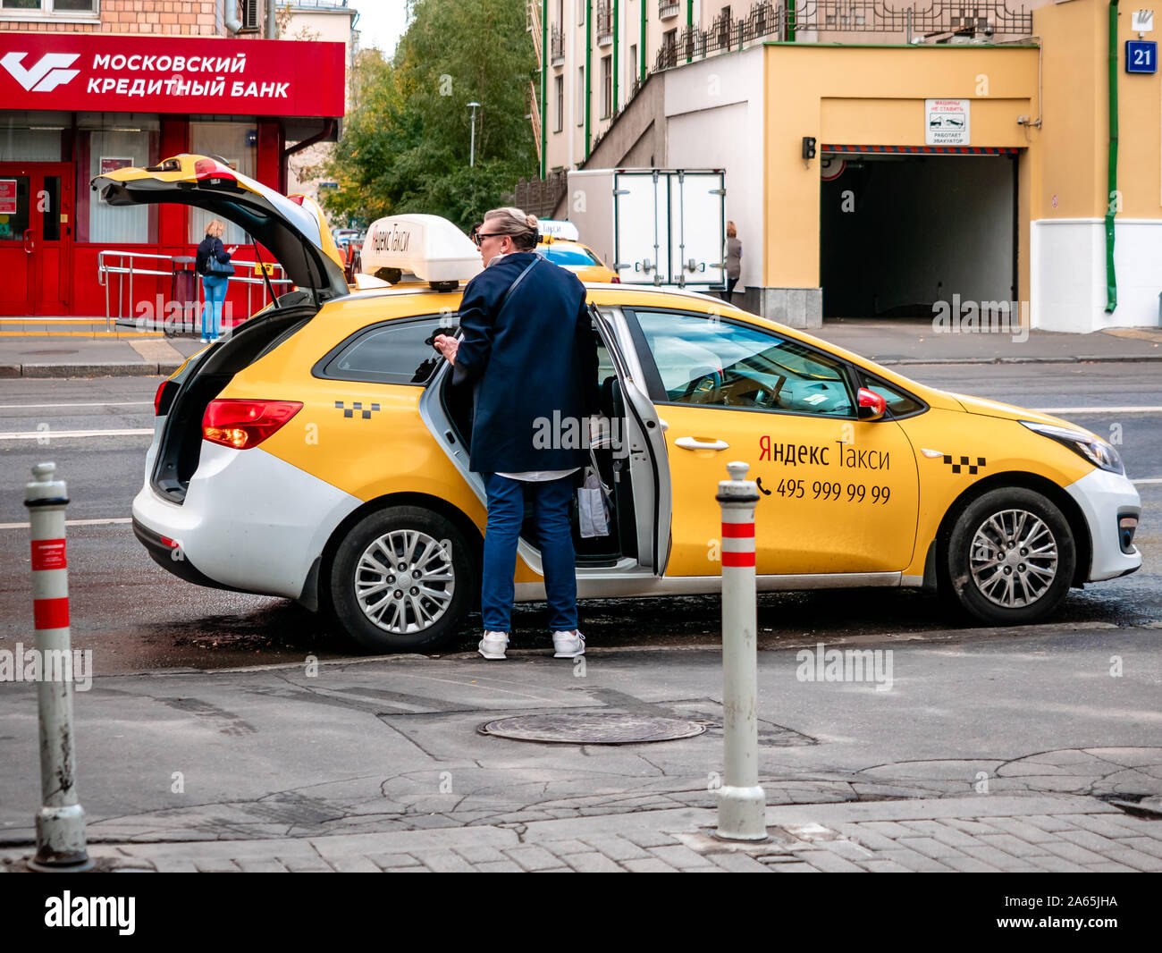 Moscow, Russia - September 14, 2019: A woman stands near a yellow taxi ...