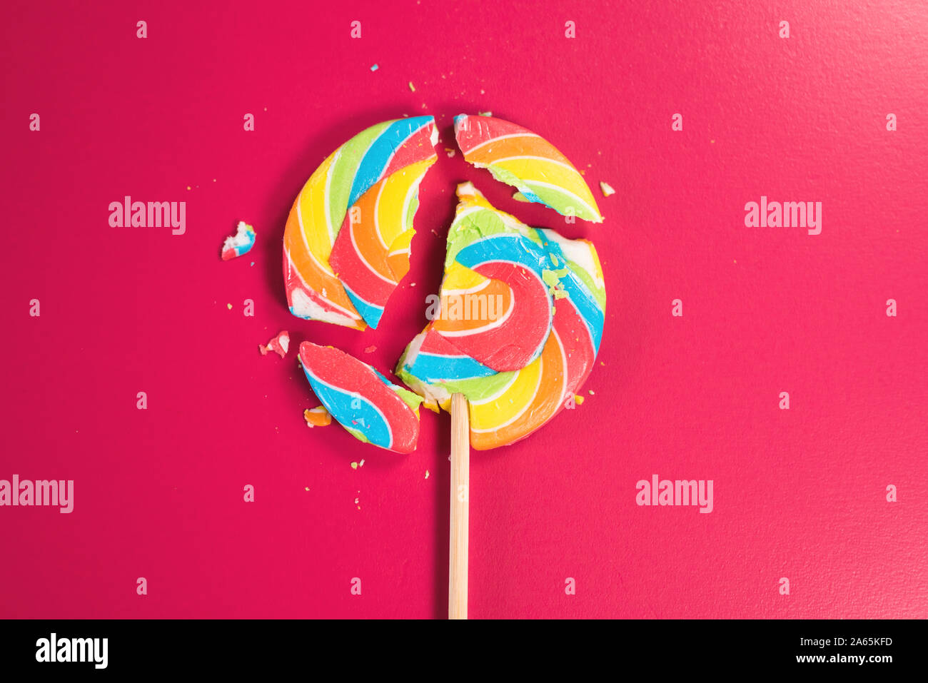 Swirl round broken lollipop on pink background. concept of unhealthy ...
