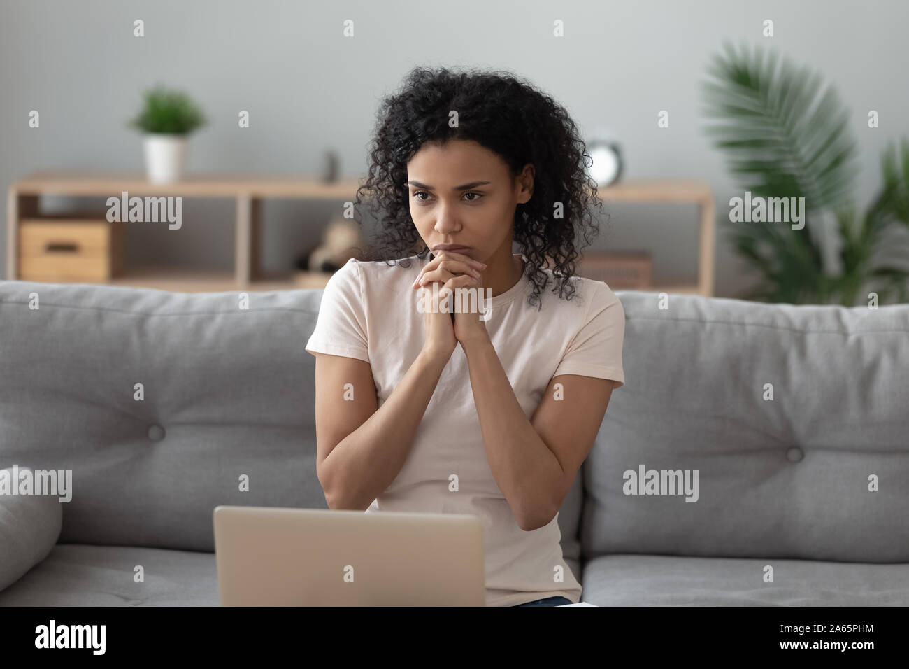 Pensive black girl busy thinking working on laptop Stock Photo - Alamy