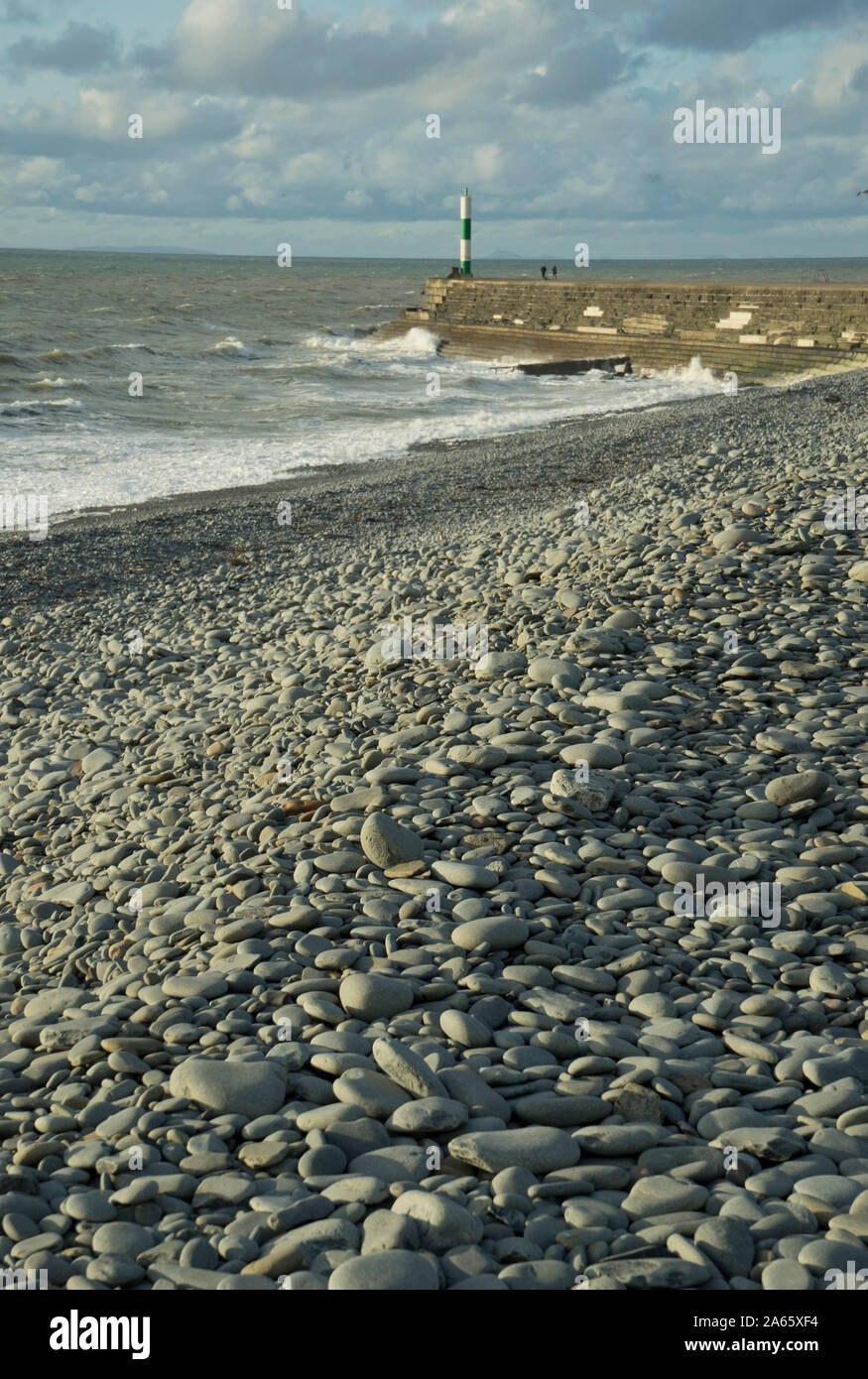 Beach with stacked limestone strata with lighthouse in background in ...