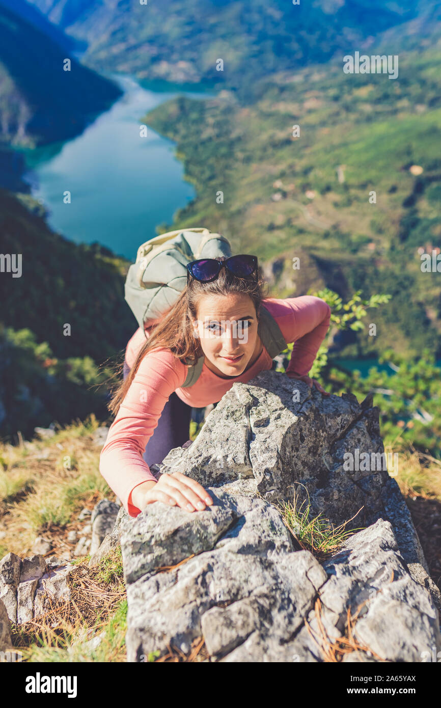 Portrait of woman hiking over extreme terrain in mountain against ...