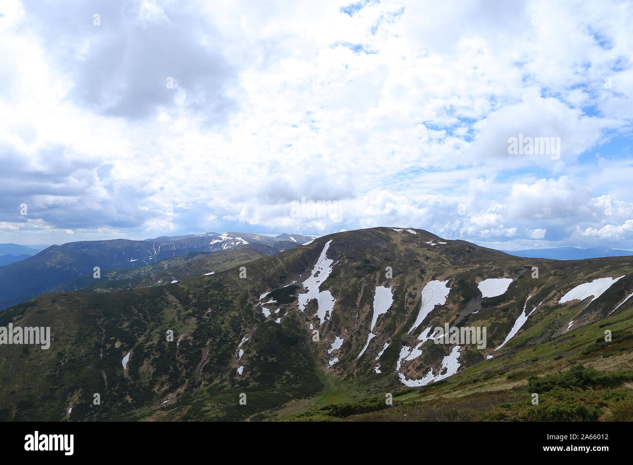 Green Alps mountains in summer season with clouds in background Stock ...