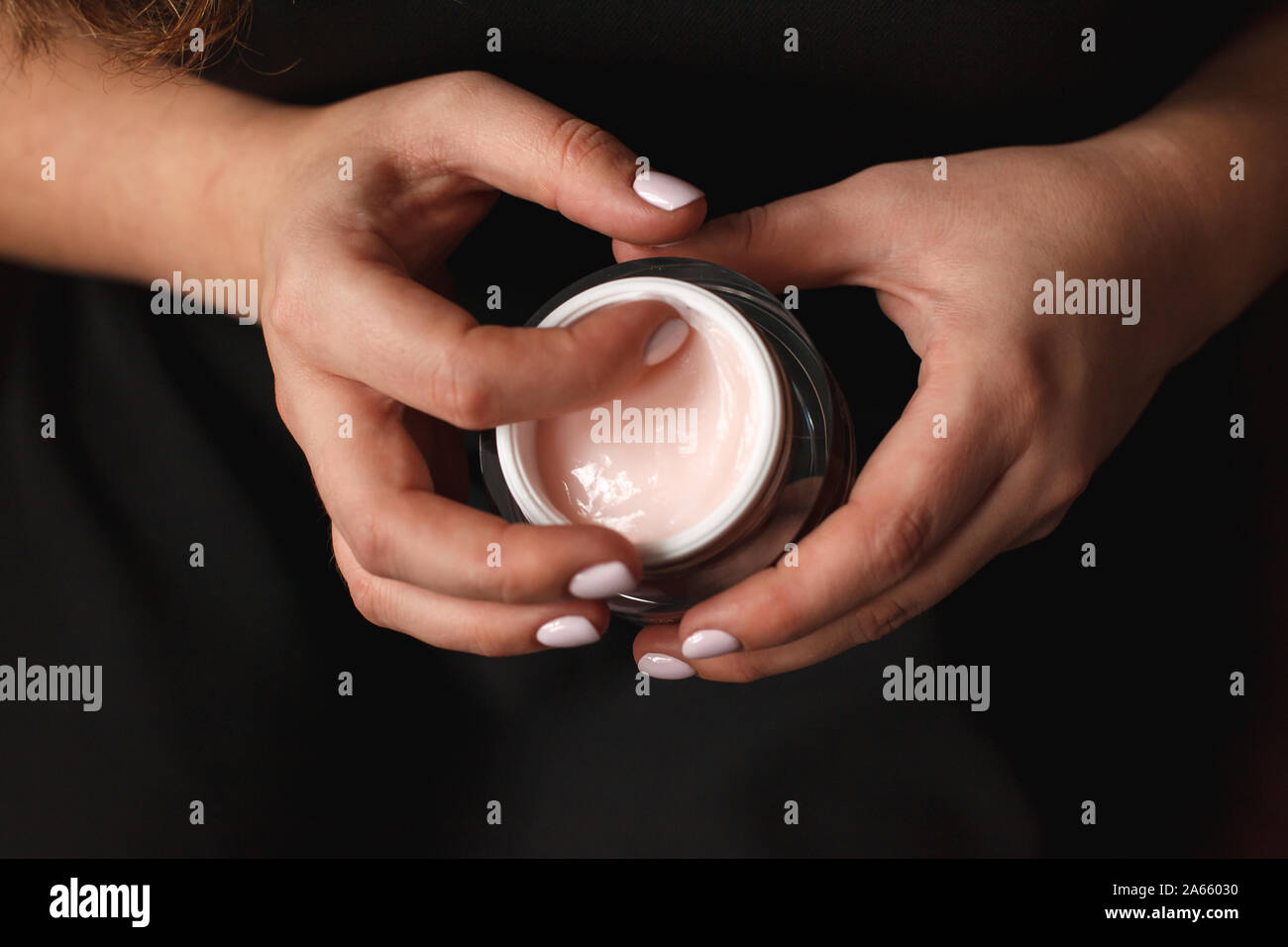 Beautiful woman hands with cream on dark background Stock Photo - Alamy