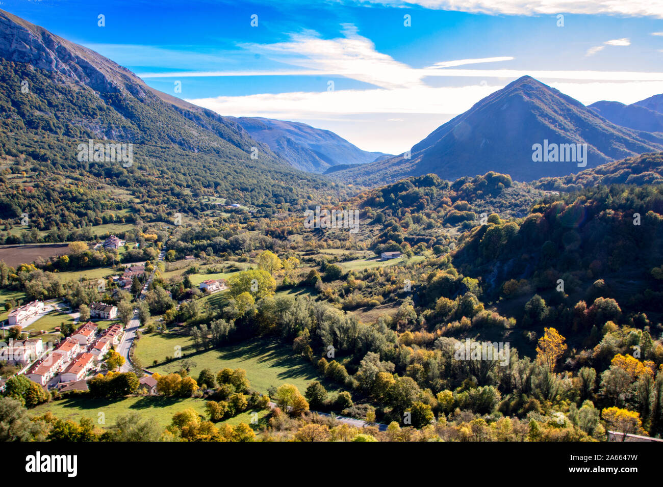 landscape of a sunny valley and mountain peaks as seen from the town of ...