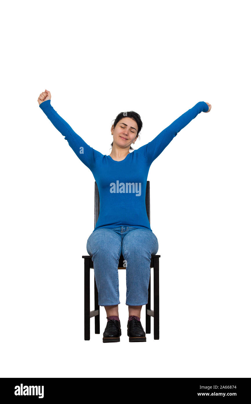 Pleased young woman sitting on a chair and relax, hands outstretched ...