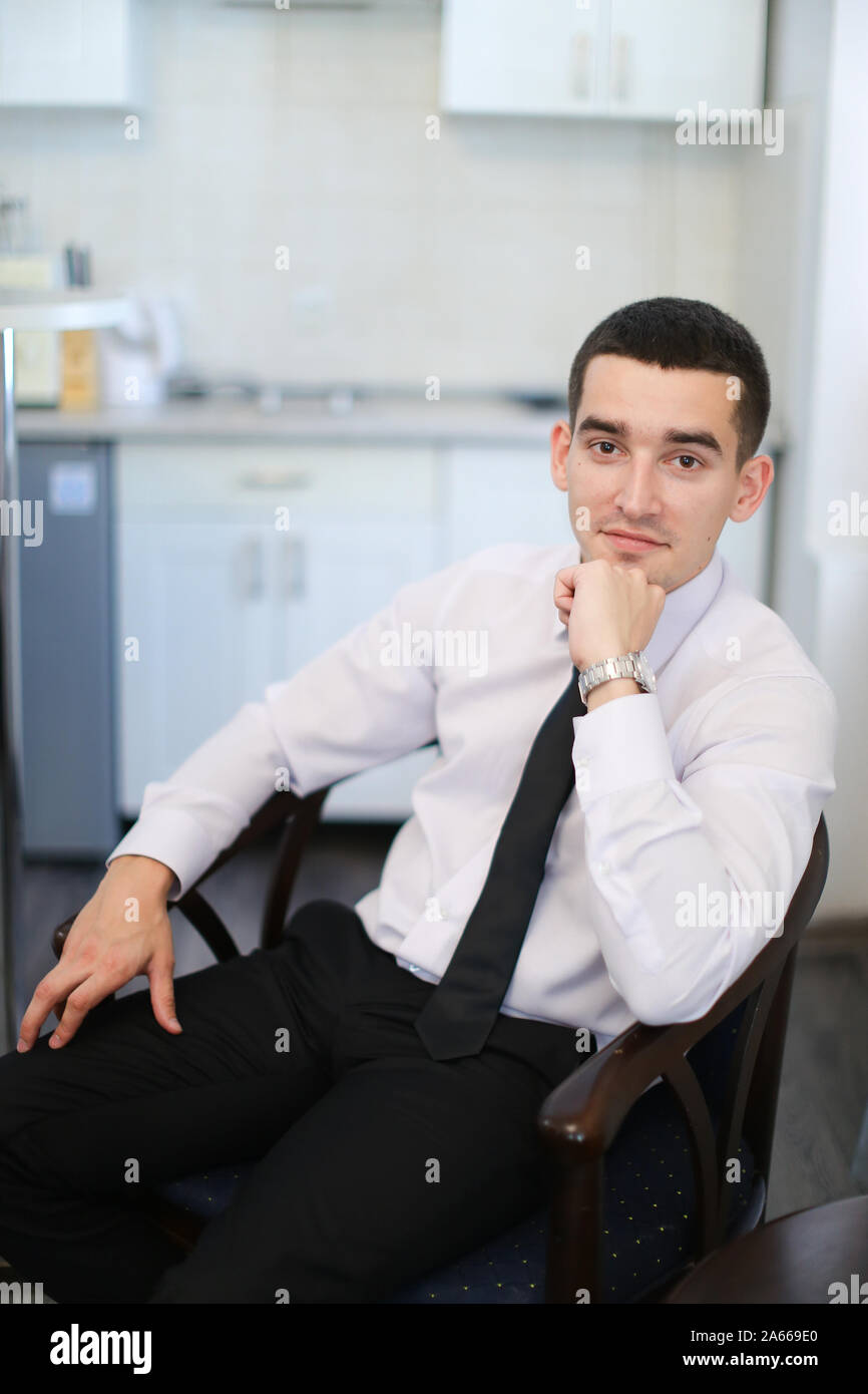 Young caucasian businessman wearing white shirt with black tie sitting ...