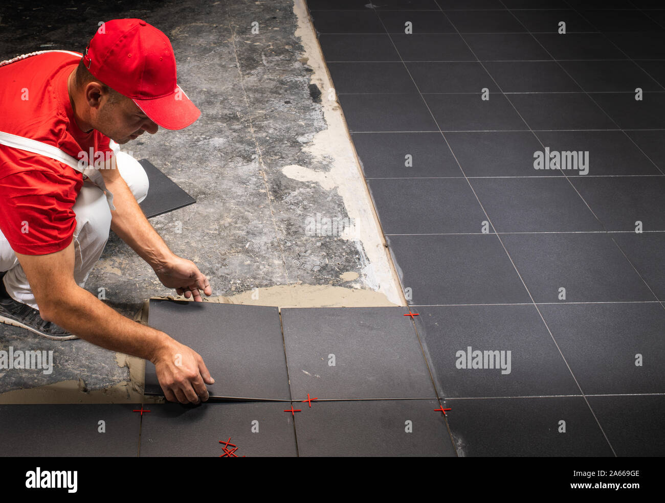 A construction worker putting on new floor tiles Stock Photo - Alamy