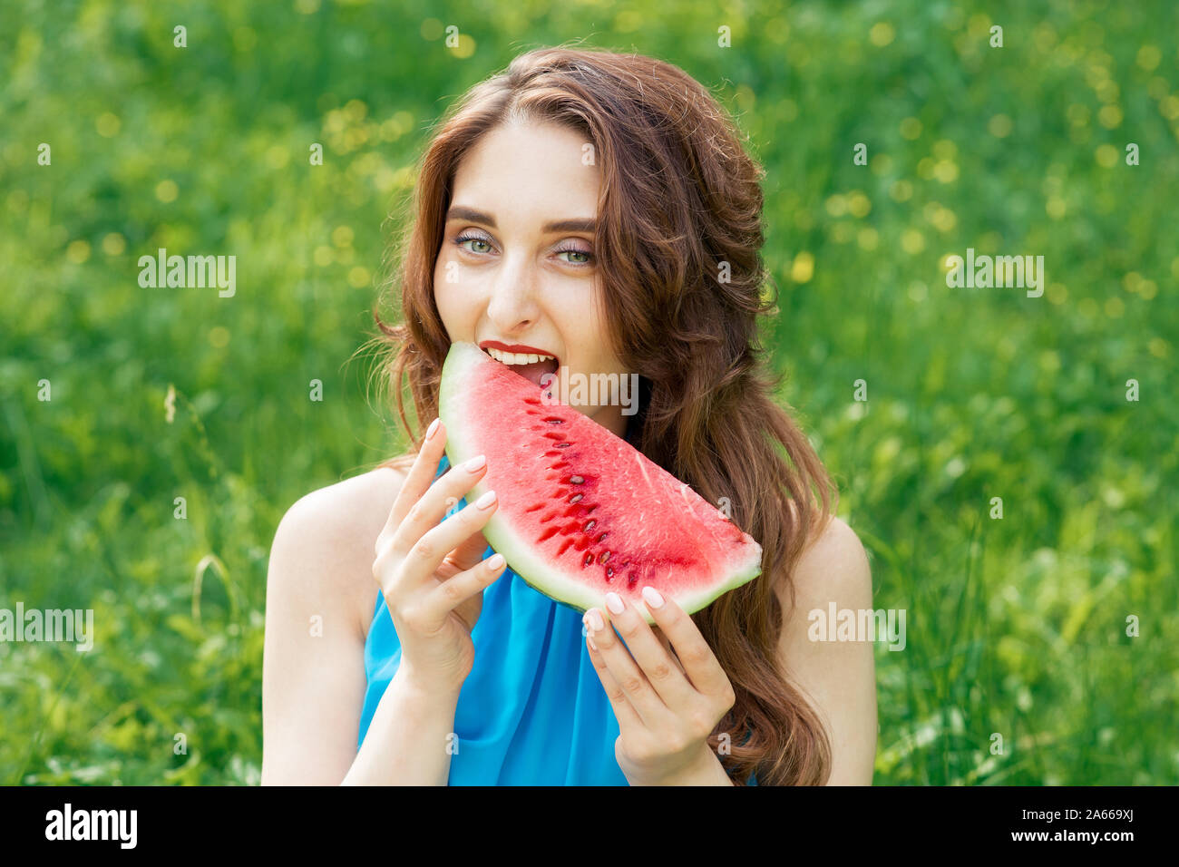 Portrait of a adult girl eating slice of watermelon on background of ...