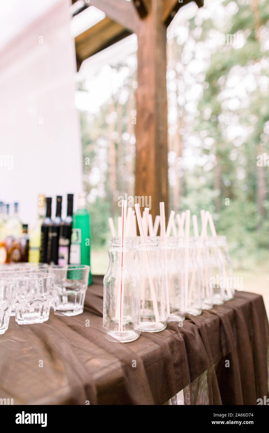 Table with glasses and alcohol bottles on background. Celebration ...