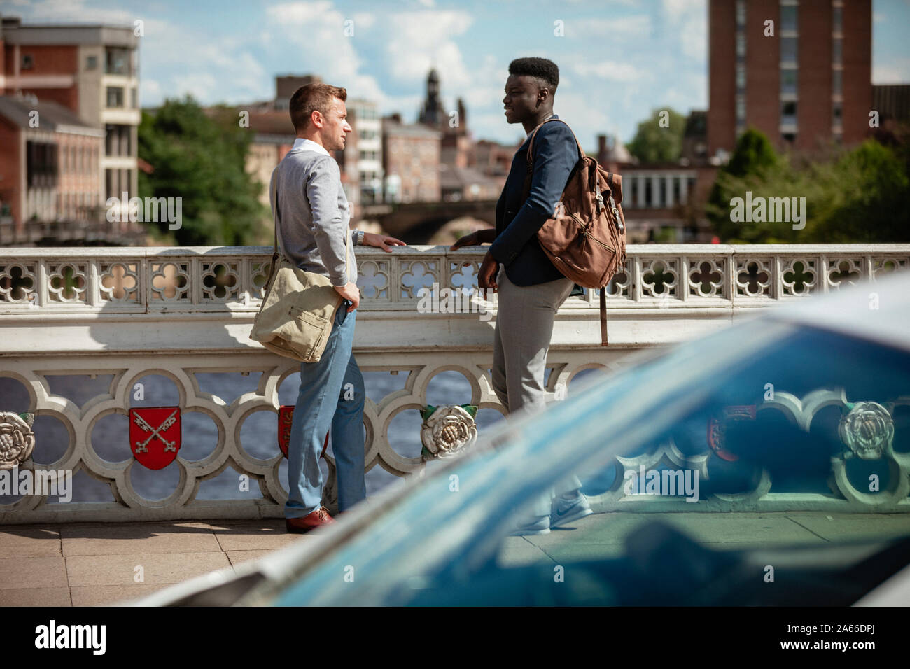 Two businessmen having a chat on a bridge in York. They are facing each ...