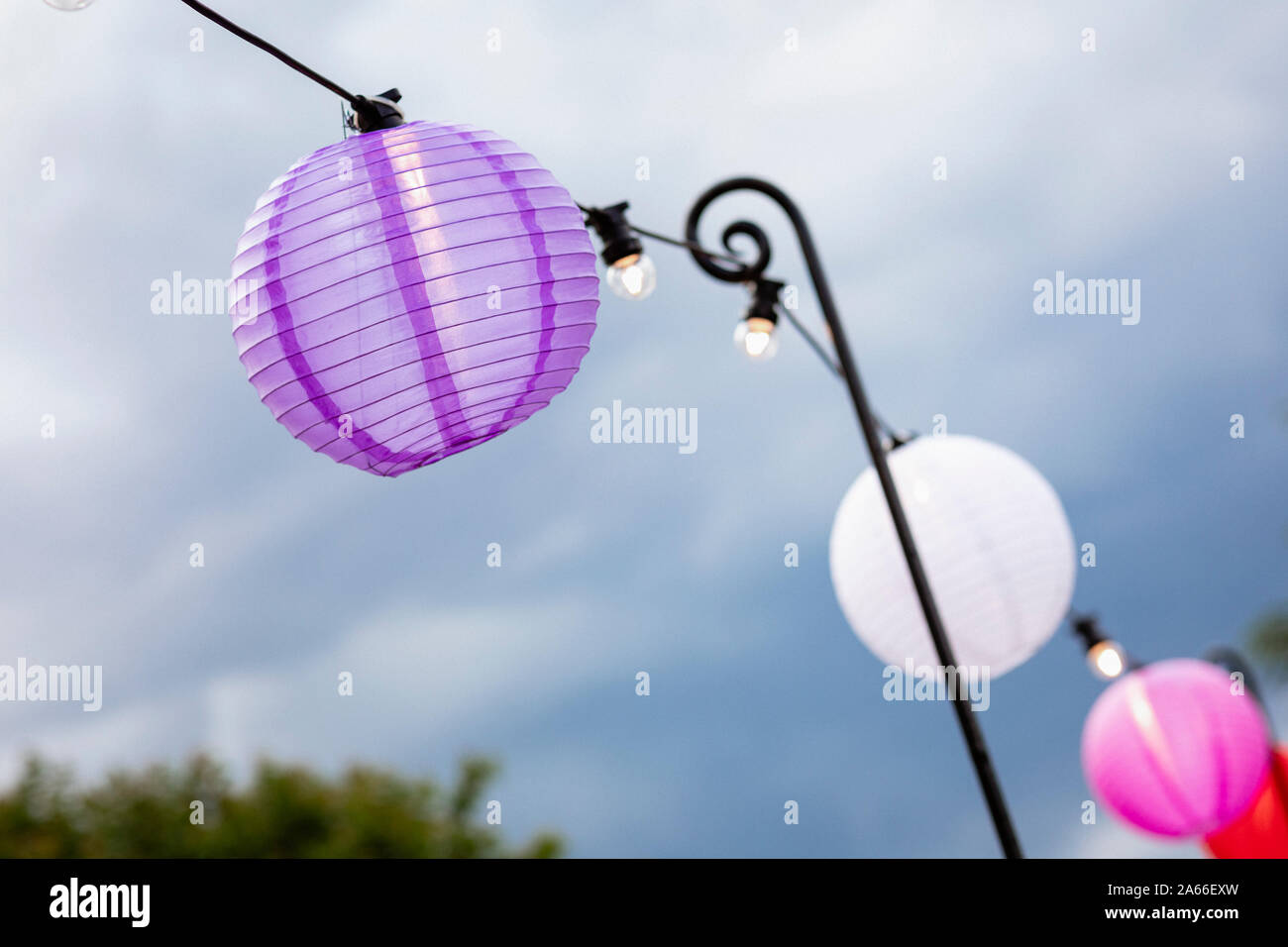 A close-up of paper lanterns hanging up alongside a set of string ...