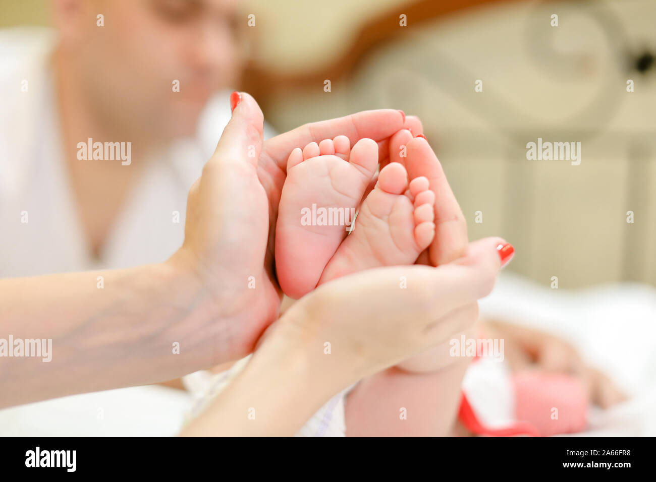 Little legs of newborn baby, father in background Stock Photo - Alamy