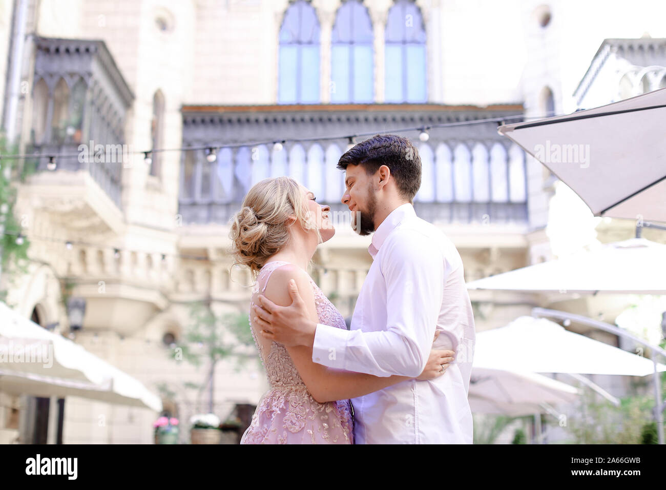 Happy young married couple hugging with building background Stock Photo ...