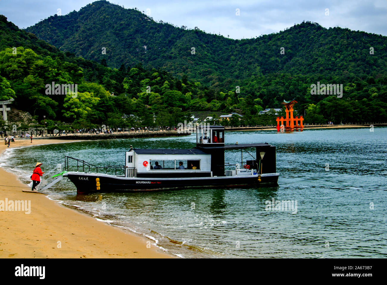 A tour boat gets ready to cast off from the beach at Miyajima Island ...