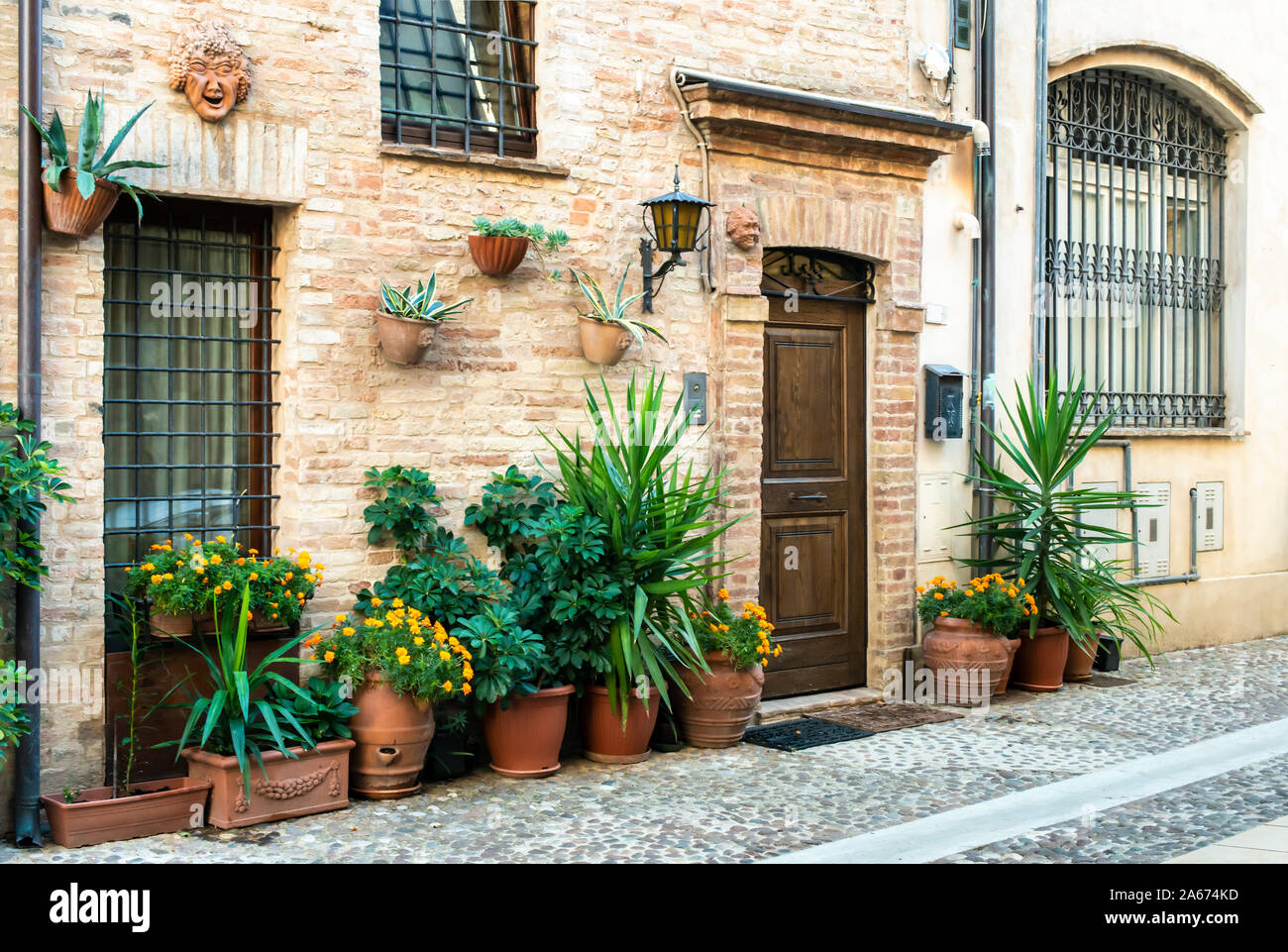 Old buildings on small italian street. Narrow street in Italy. Flowers ...