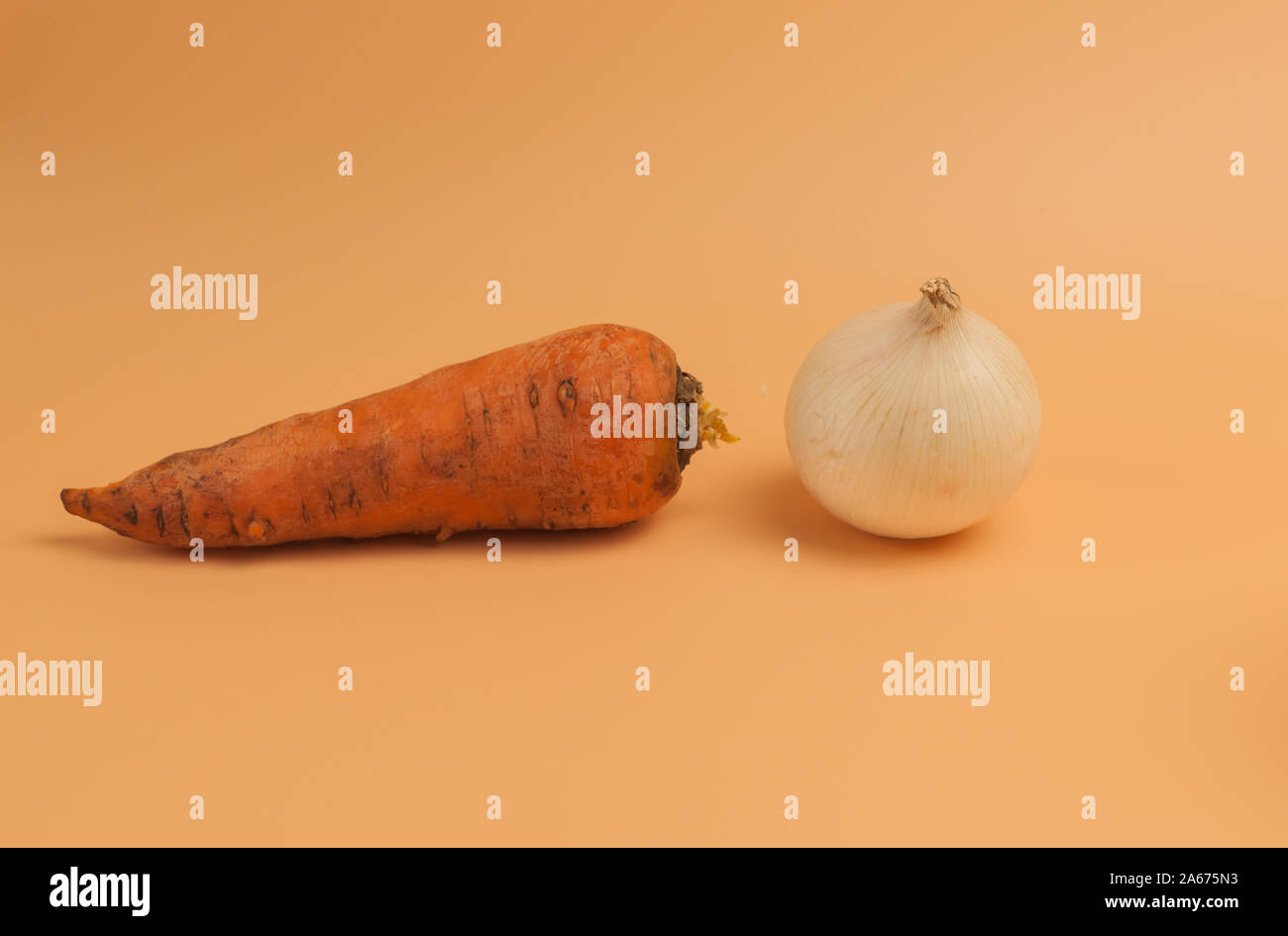 organic carrots and onions on a beige background, unpeeled sweet ...