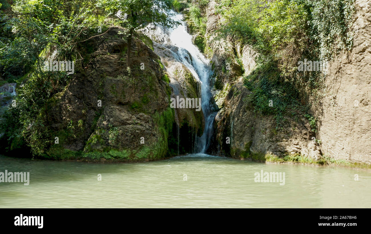 View with a waterfall in the mountains that flows into a lake. Drones ...