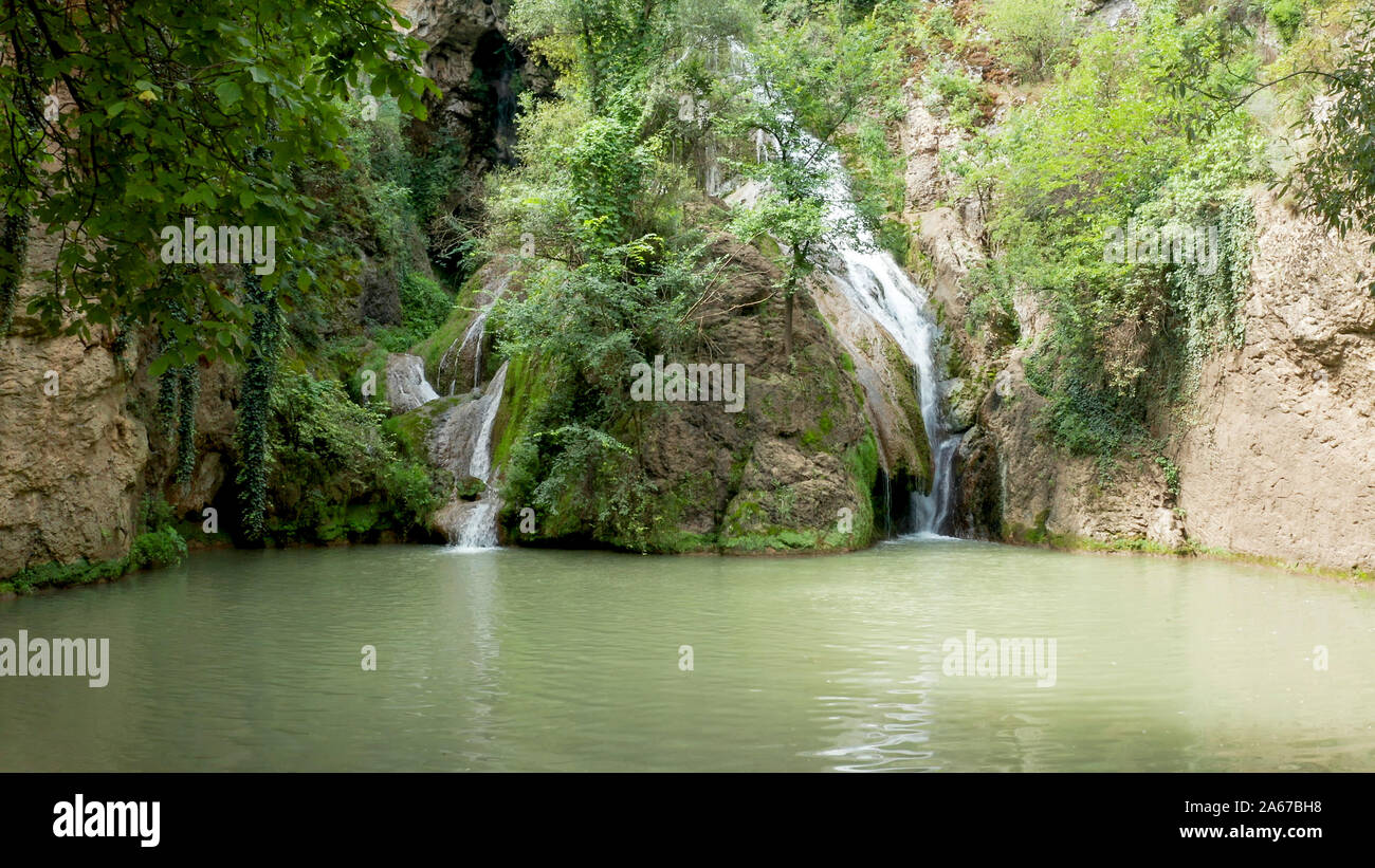 View with a waterfall and a lake surrounded by greenery. Landscape view ...