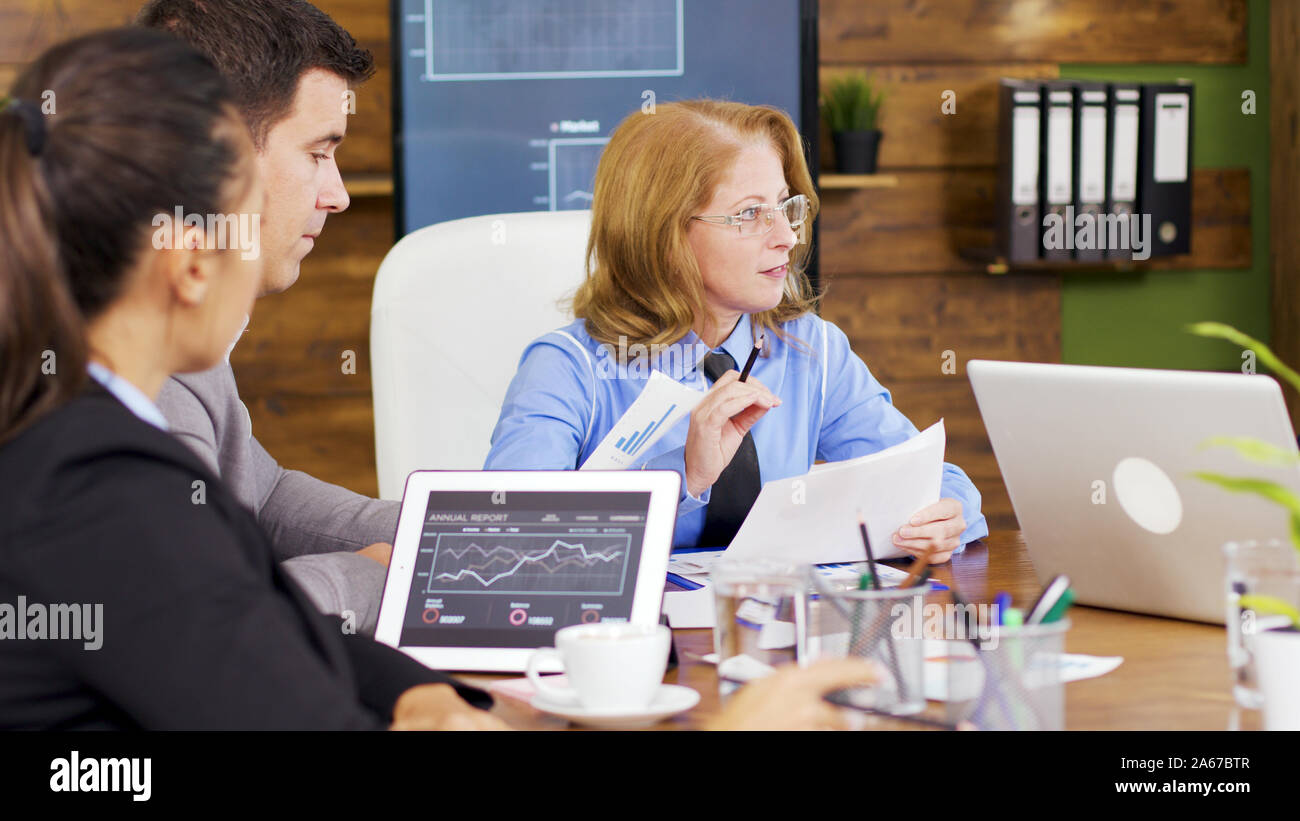 Corporate female business trainer discussing financial graph ...